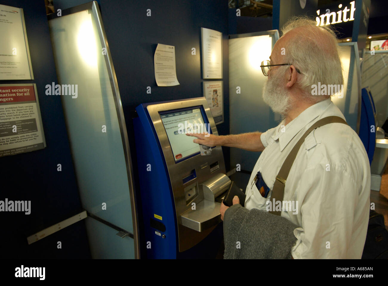 Male Passenger (60s) using self check in at Heathrow Airport Terminal 4 ...