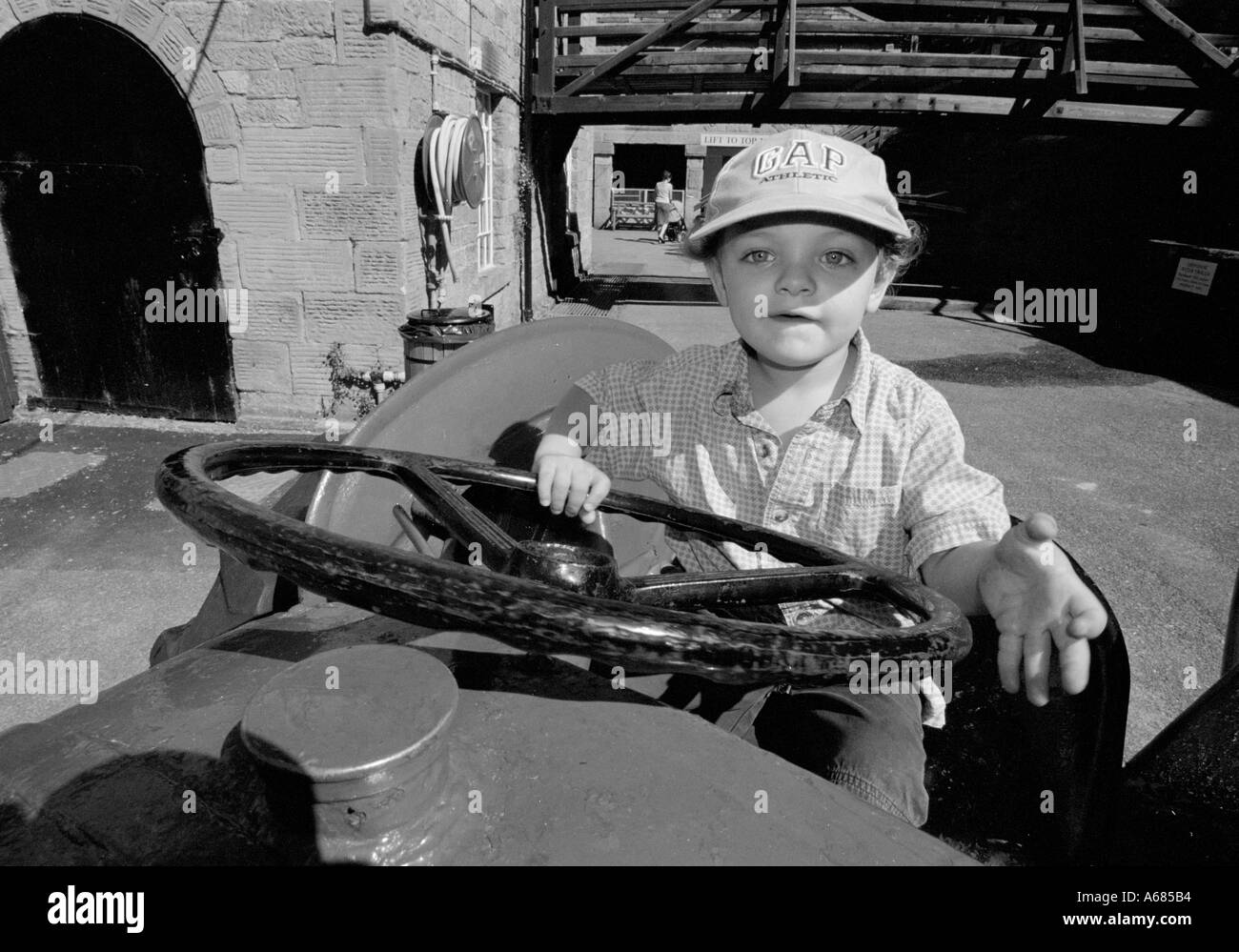young boy on a farm driving a tractor Stock Photo - Alamy
