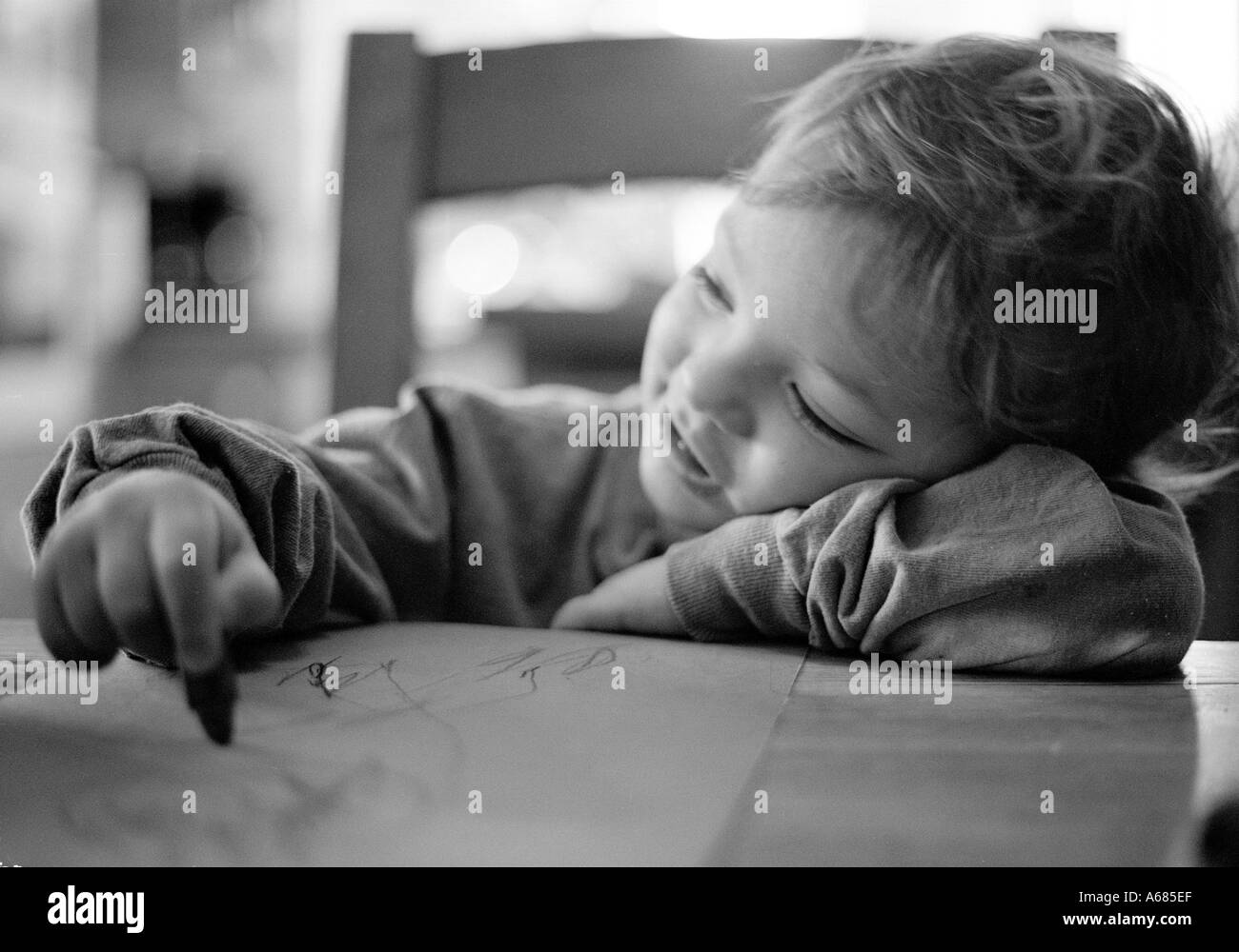 happy boy drawing at a table Stock Photo - Alamy