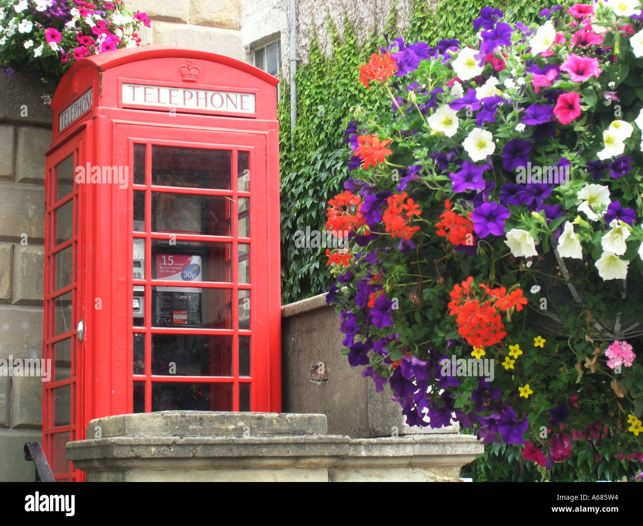 Detail of single red phone box with hanging flower baskets Glastonbury ...