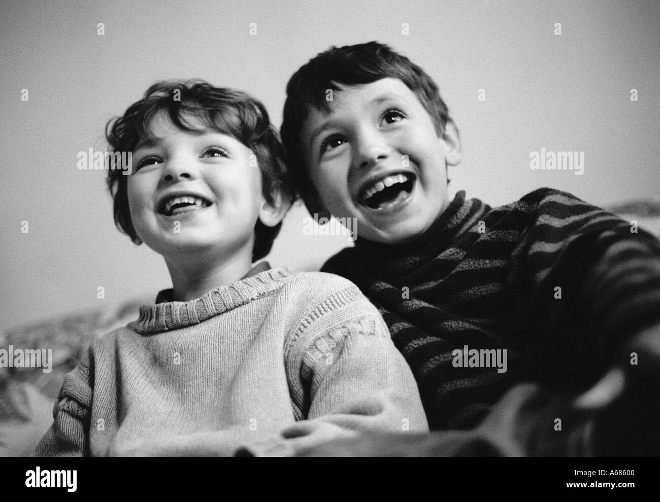two boys sat on couch enjoying watching television Stock Photo - Alamy
