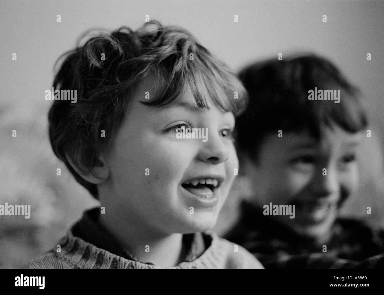 two boys sat on couch enjoying watching television Stock Photo - Alamy