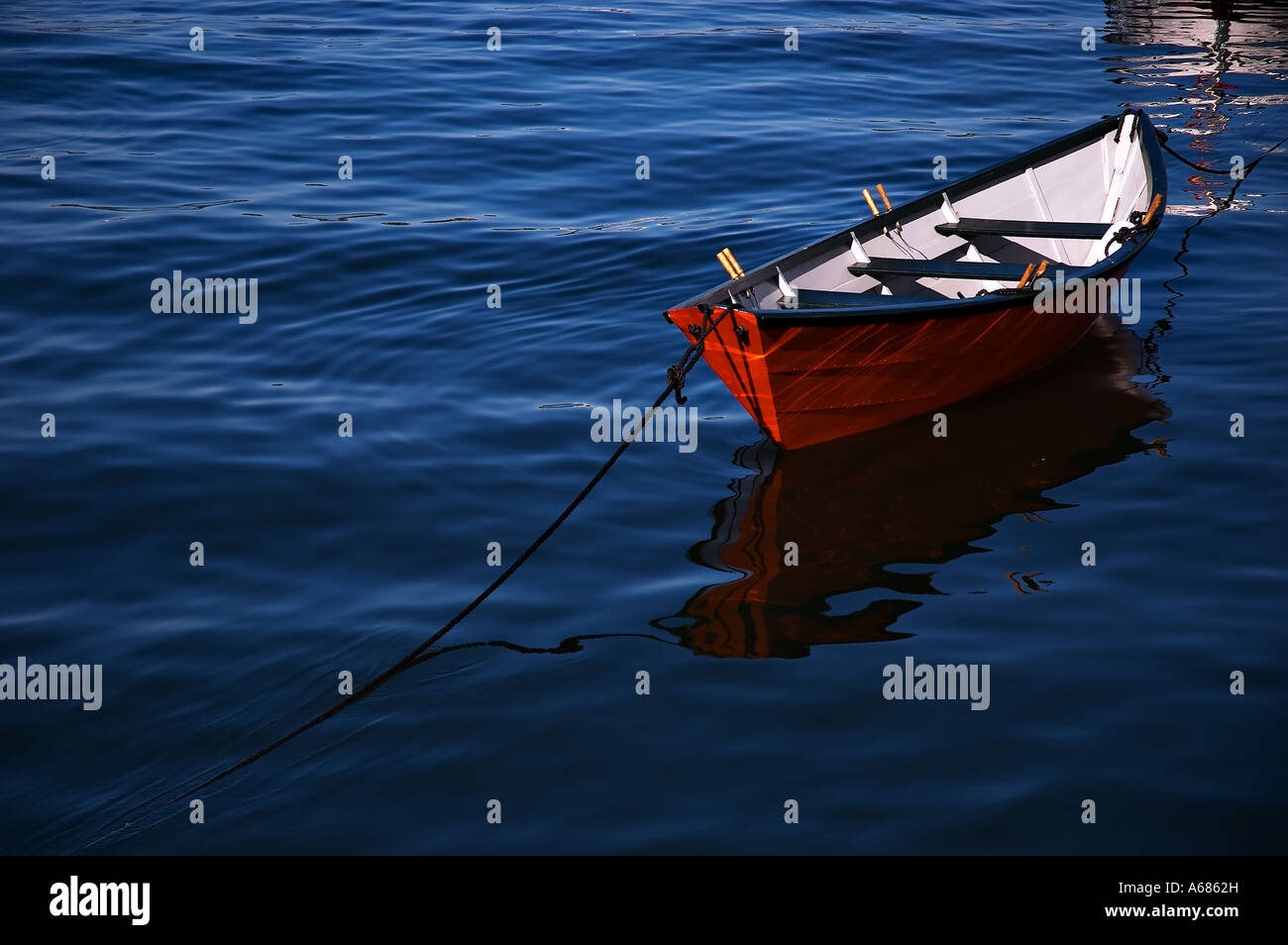 A row boat anchored close to shore Stock Photo - Alamy