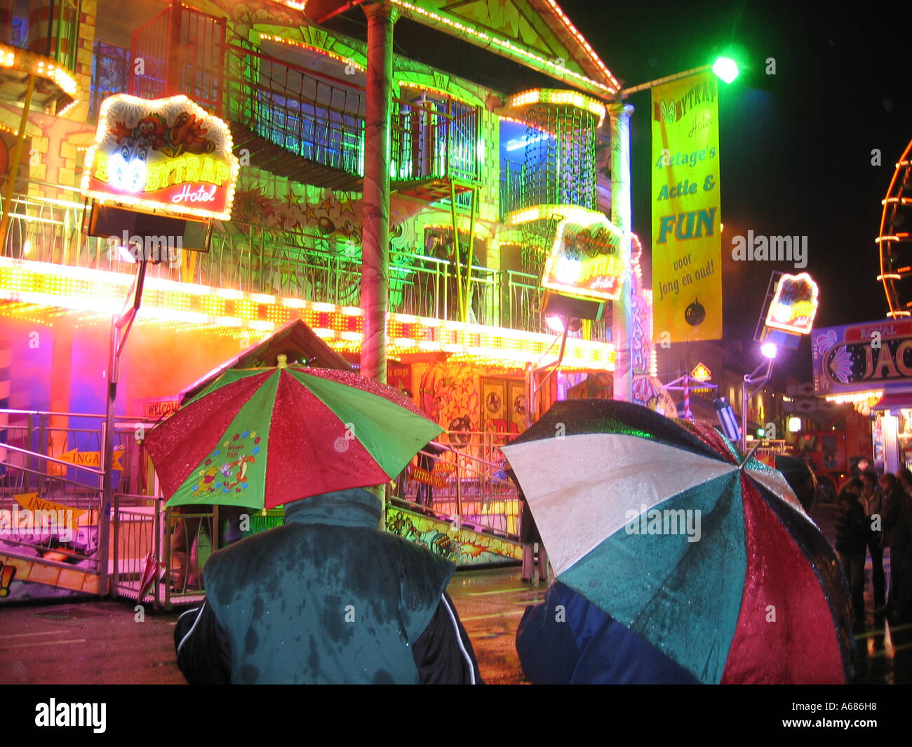 spectators watching fairground attraction with neon lights in the ...