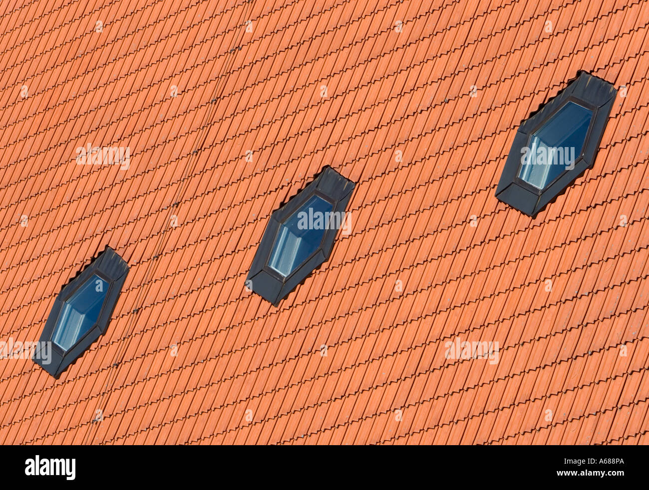 Three pentagon shaped skylight windows in orange tile roof Stock Photo ...