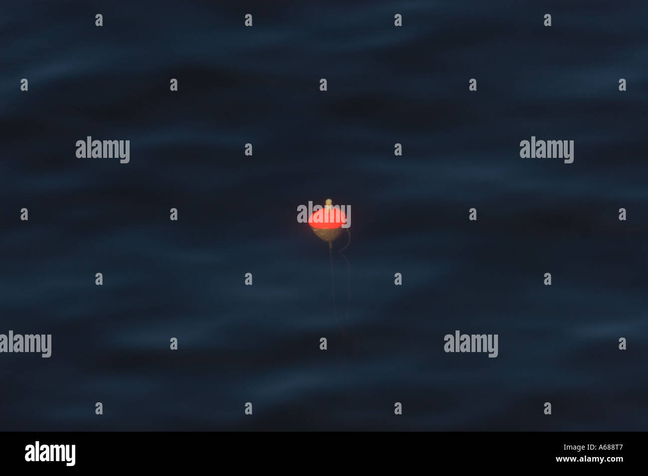 Bright red float submerged in dark black water Stock Photo - Alamy