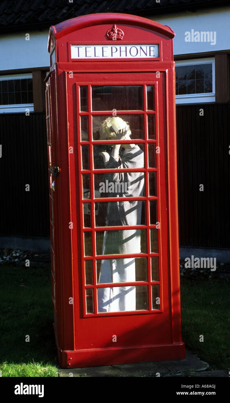 Traditional red telephone box displayed in a garden of a house in ...