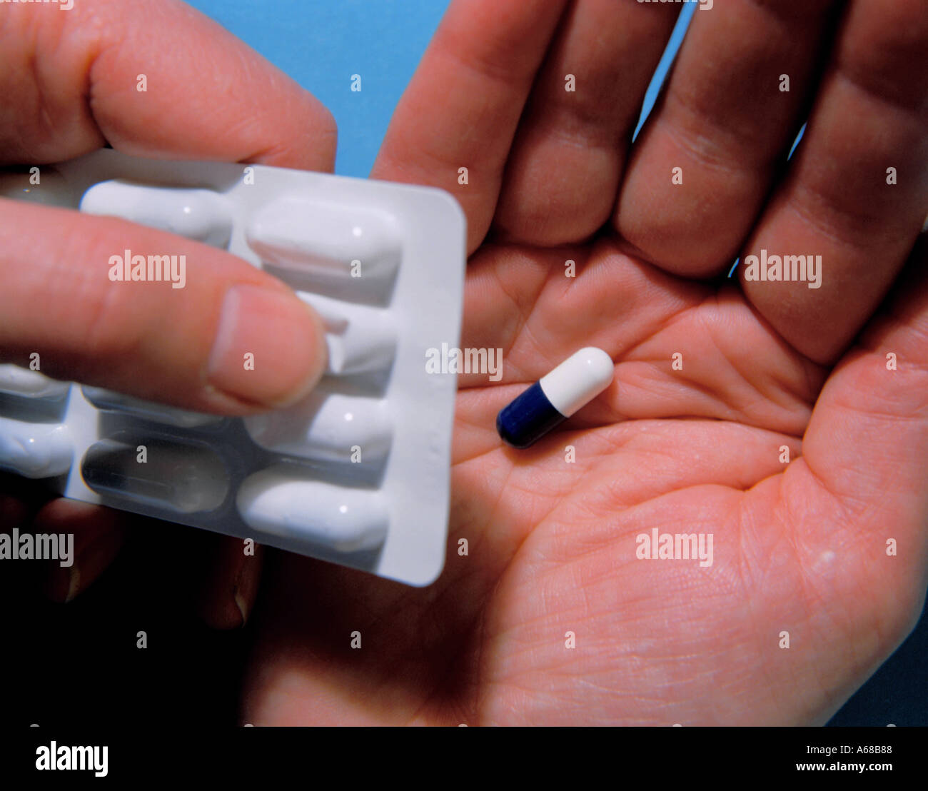 Placing a capsule in the palm of a hand from a sealed pack Stock Photo ...