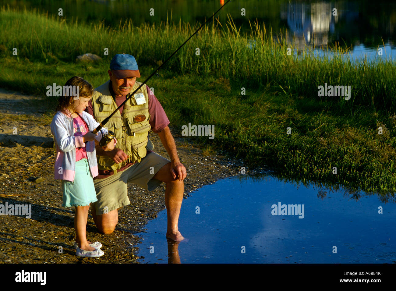 Man teaching his granddaughter to fish Mill Pond Orleans Cape Cod MA ...