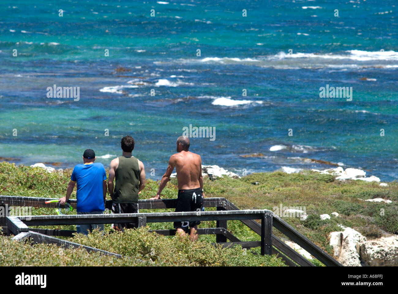 Three men gaze on a rough sea Stock Photo - Alamy
