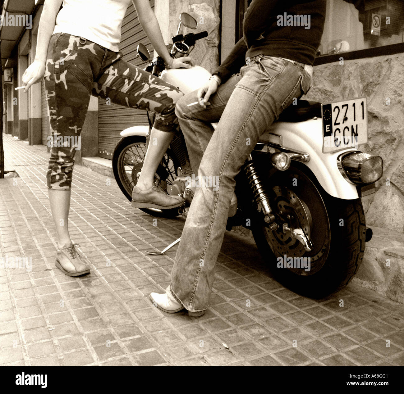 Two girls sat down in a motorbike Stock Photo - Alamy