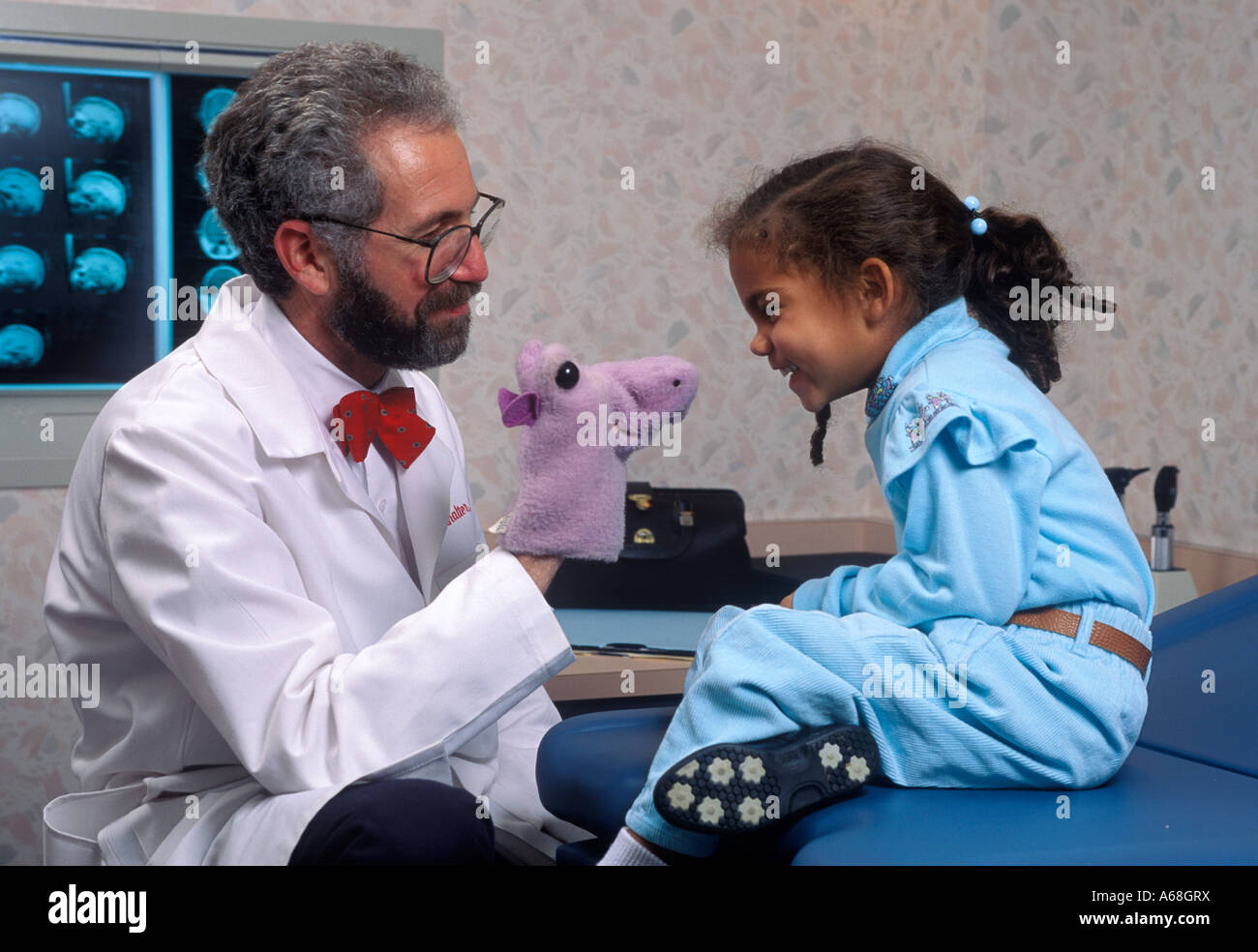 Pediatric doctor relaxes a young patient with a hand puppet Stock Photo ...
