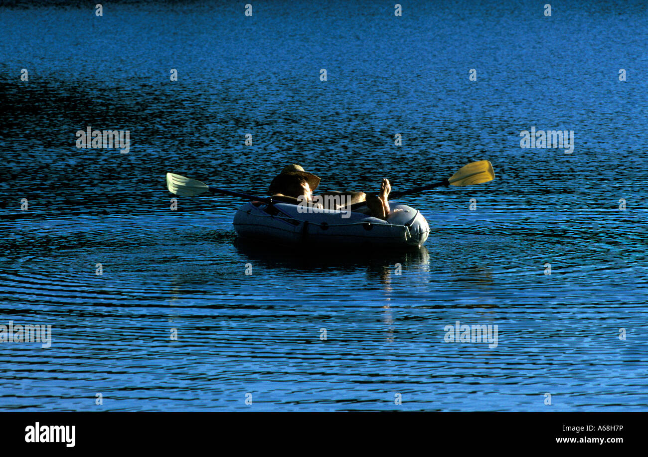 Senior man relaxes in an inflatable raft boat on a lake Crystal Lake ...