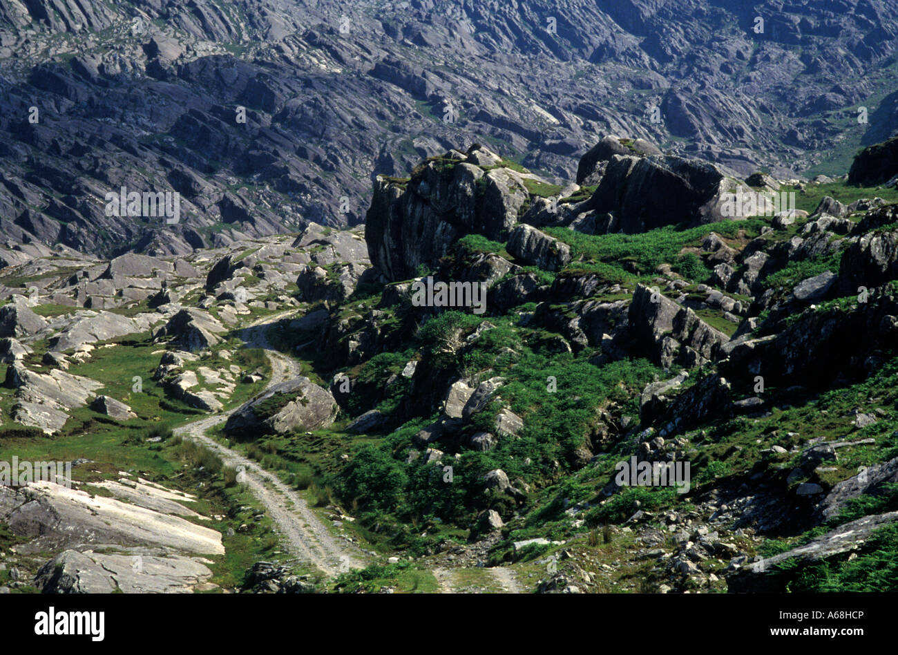 Narrow dirt road through the rocky karstic limestone Burren mountains ...