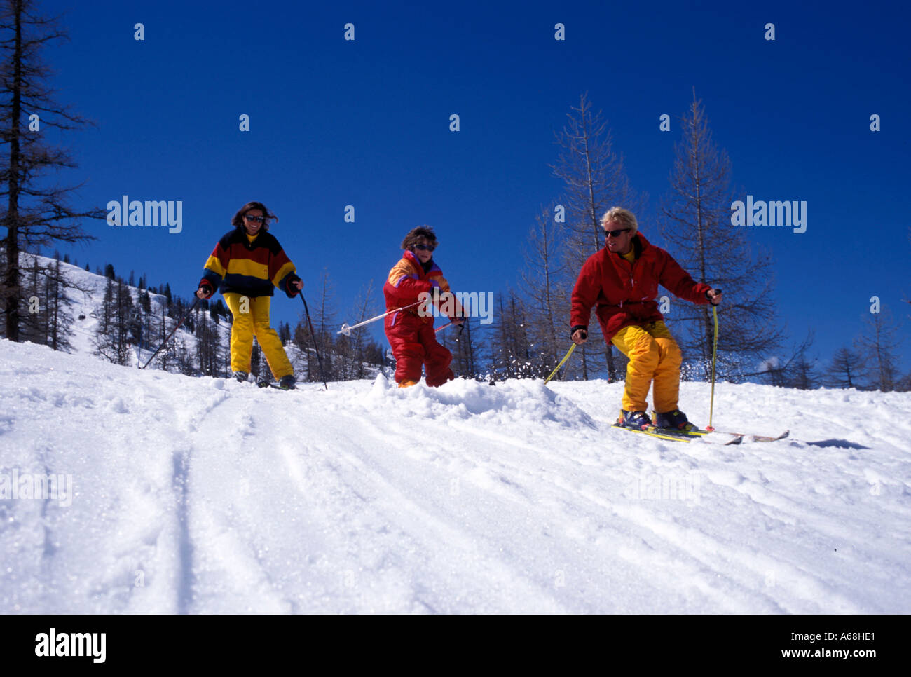 Ski instructor teaching young children how to ski Stock Photo - Alamy