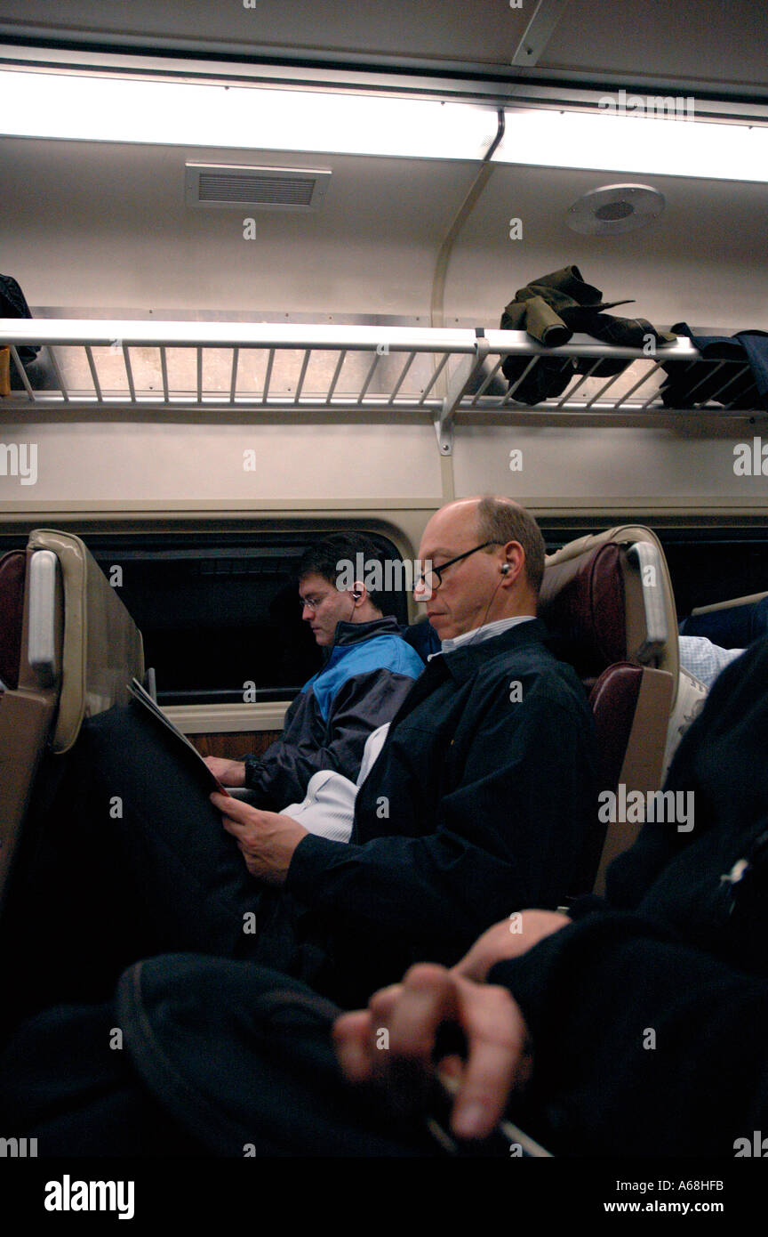 Commuters reading newspapers travelling into New York by train to work ...