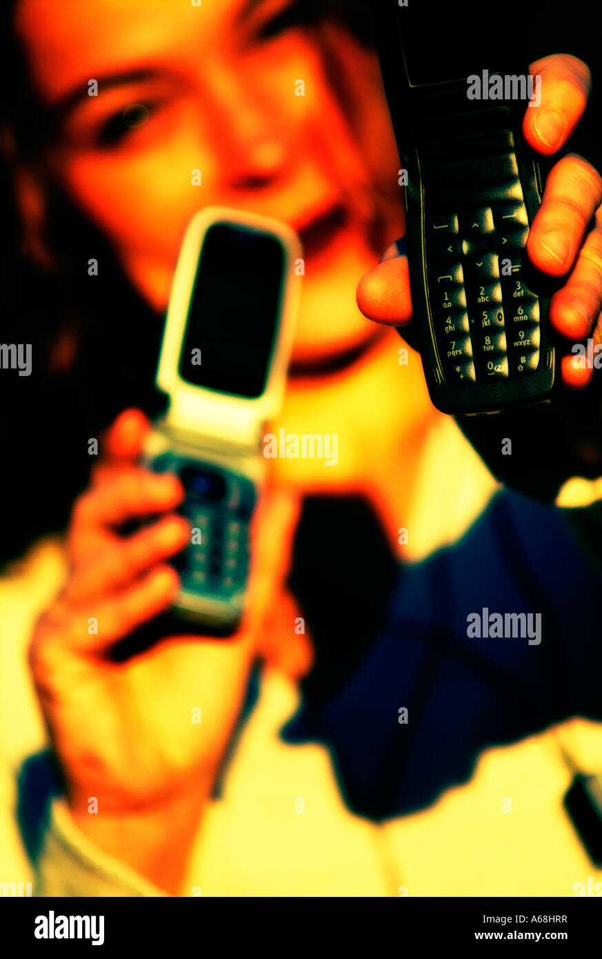 Young girl showing two cellular phones outside, with sunset light Stock ...