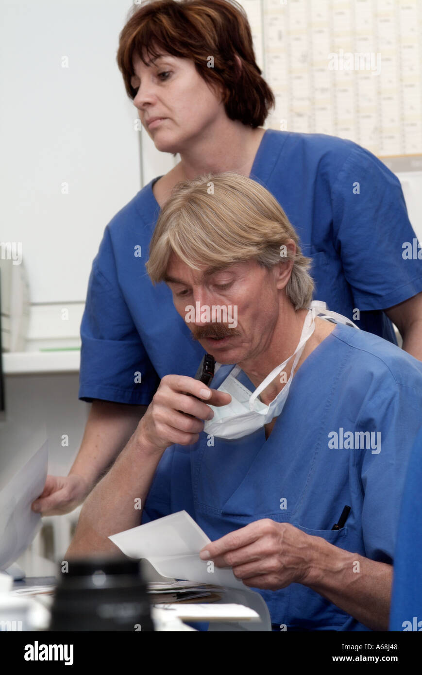 Doctor reading data to a dictaphone Stock Photo - Alamy