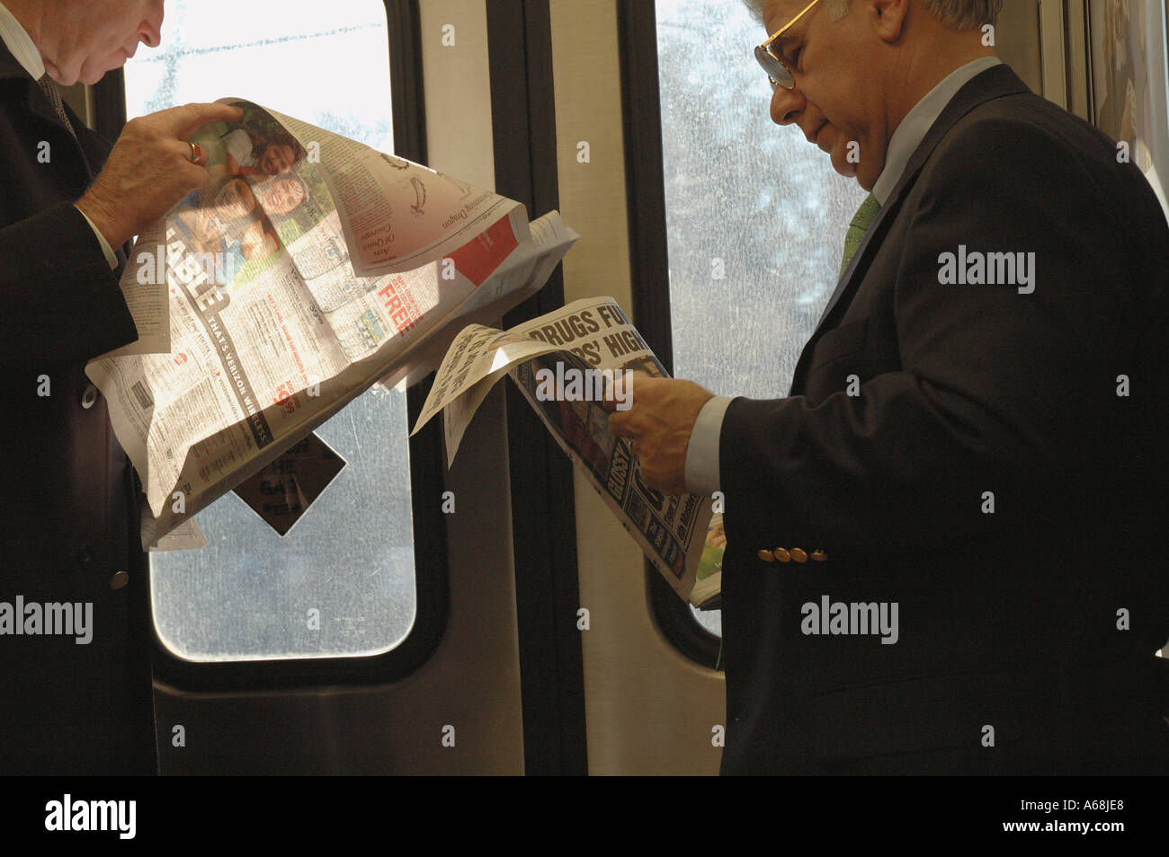 Commuters reading newspapers travelling into New York by train to work ...