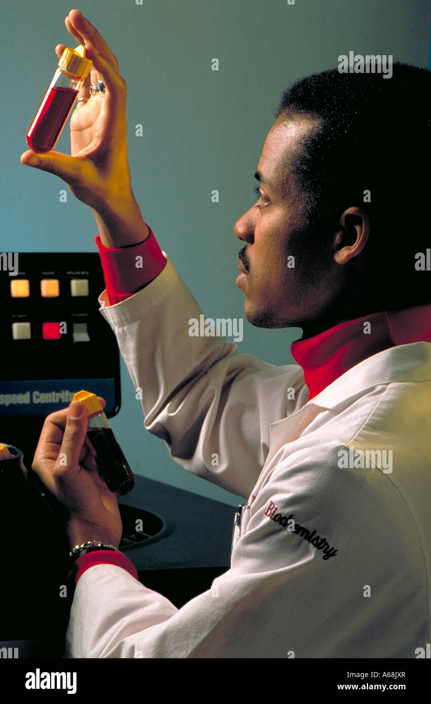 Biochemist inspecting a vile of fluid Stock Photo - Alamy