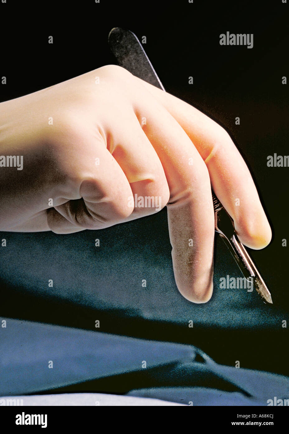 Gloved hand of a surgeon holding a scalpel Stock Photo - Alamy