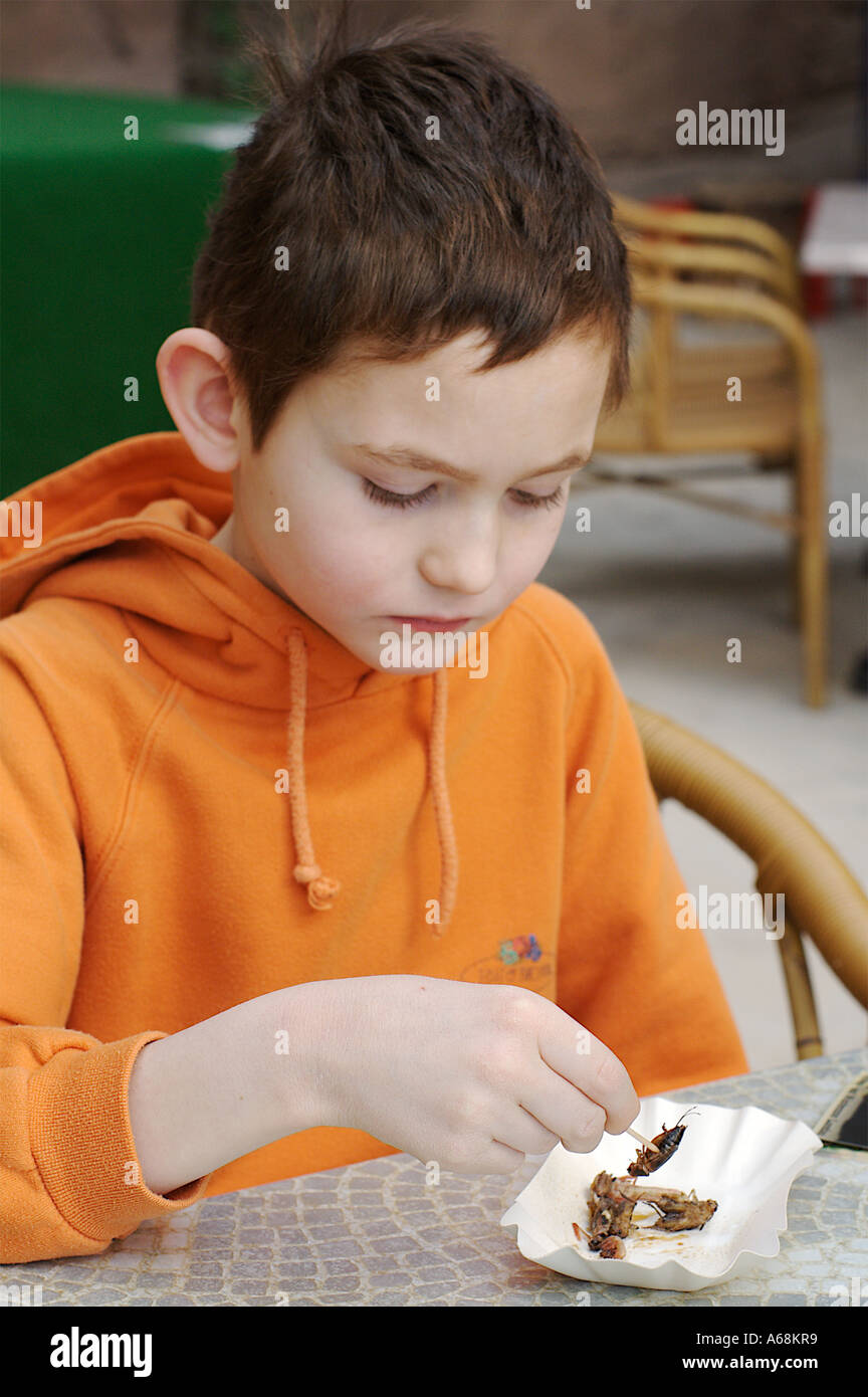 Boy eating insects Stock Photo - Alamy