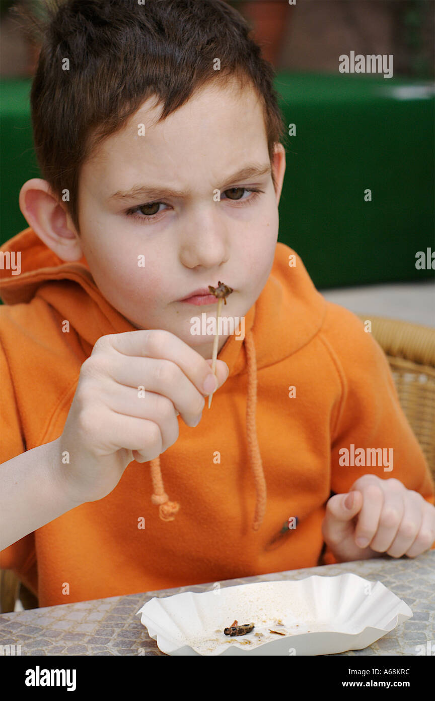 Boy eating insects Stock Photo - Alamy