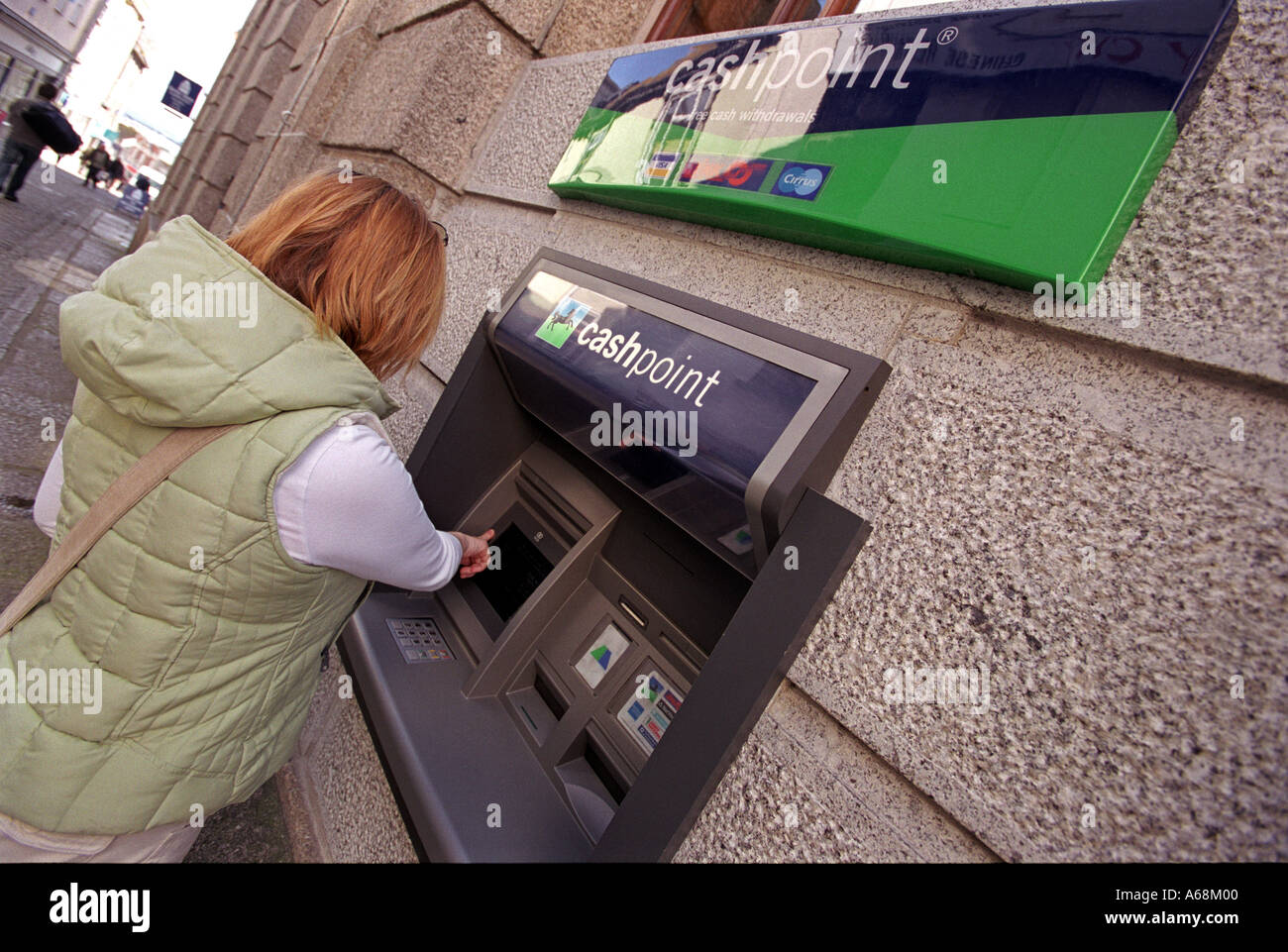 A woman using a cashpoint Stock Photo - Alamy