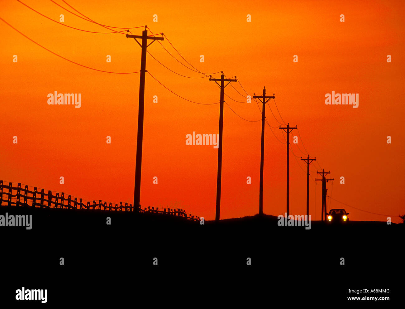 The distant headlights of a lone approaching car as it travels over a ...