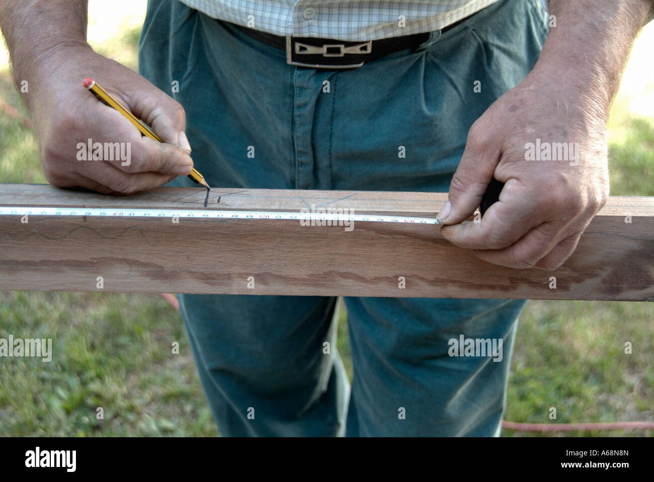 A carpenter taking measurements on wood Stock Photo - Alamy