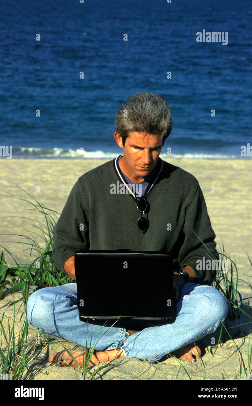Man working on a laptop computer while at the beach Stock Photo - Alamy