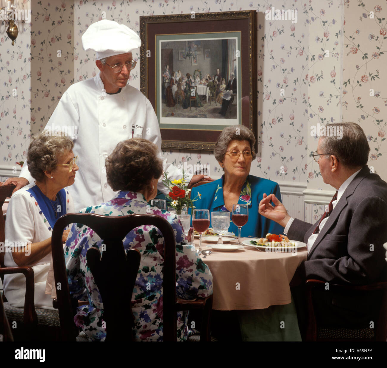 Chef visits with a group of seniors in an assisted living facility ...