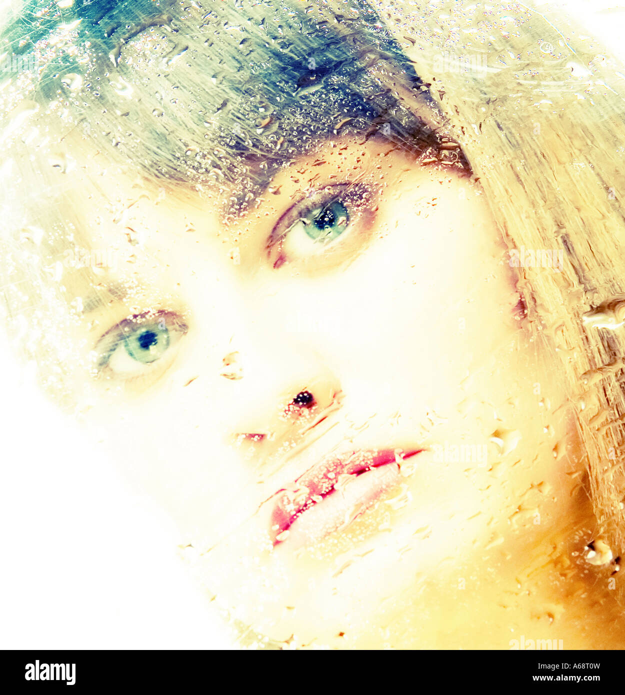 Close up of woman looking through water streaked glass Stock Photo - Alamy