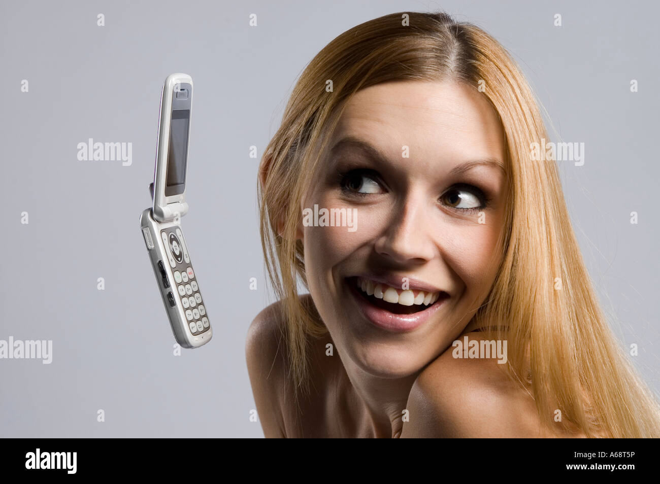 Medium shot of a blonde woman interacting with a floating cell phone ...