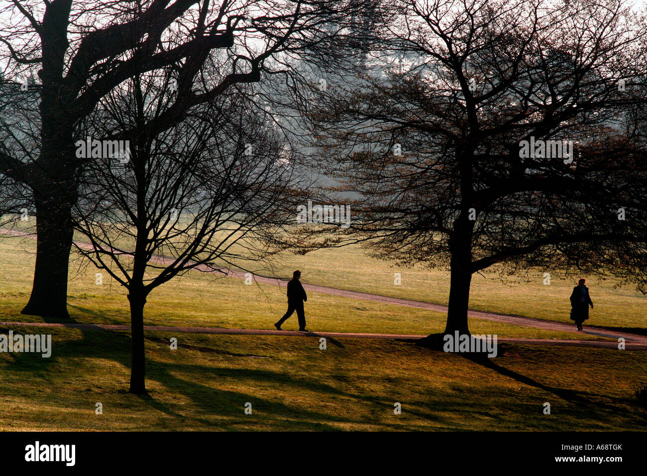 Two figures walk in an English Park Suffolk UK Stock Photo - Alamy