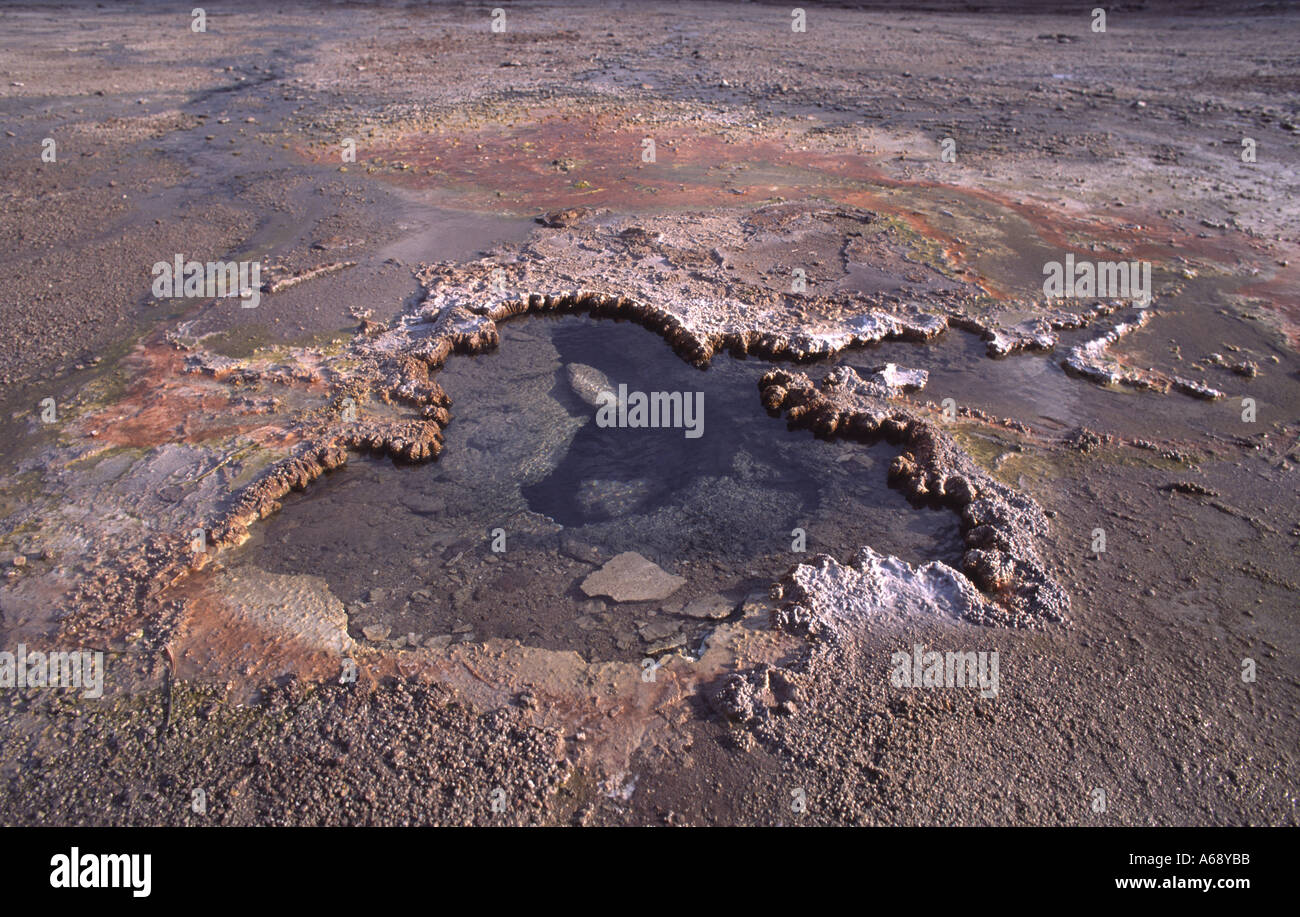 Hot crystal clear water spills from a geothermal pool at the Tatio ...