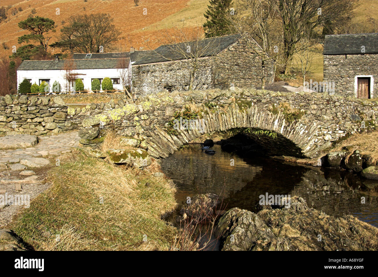 Pack horse bridge over the Watendlath Beck with farm buildings in ...