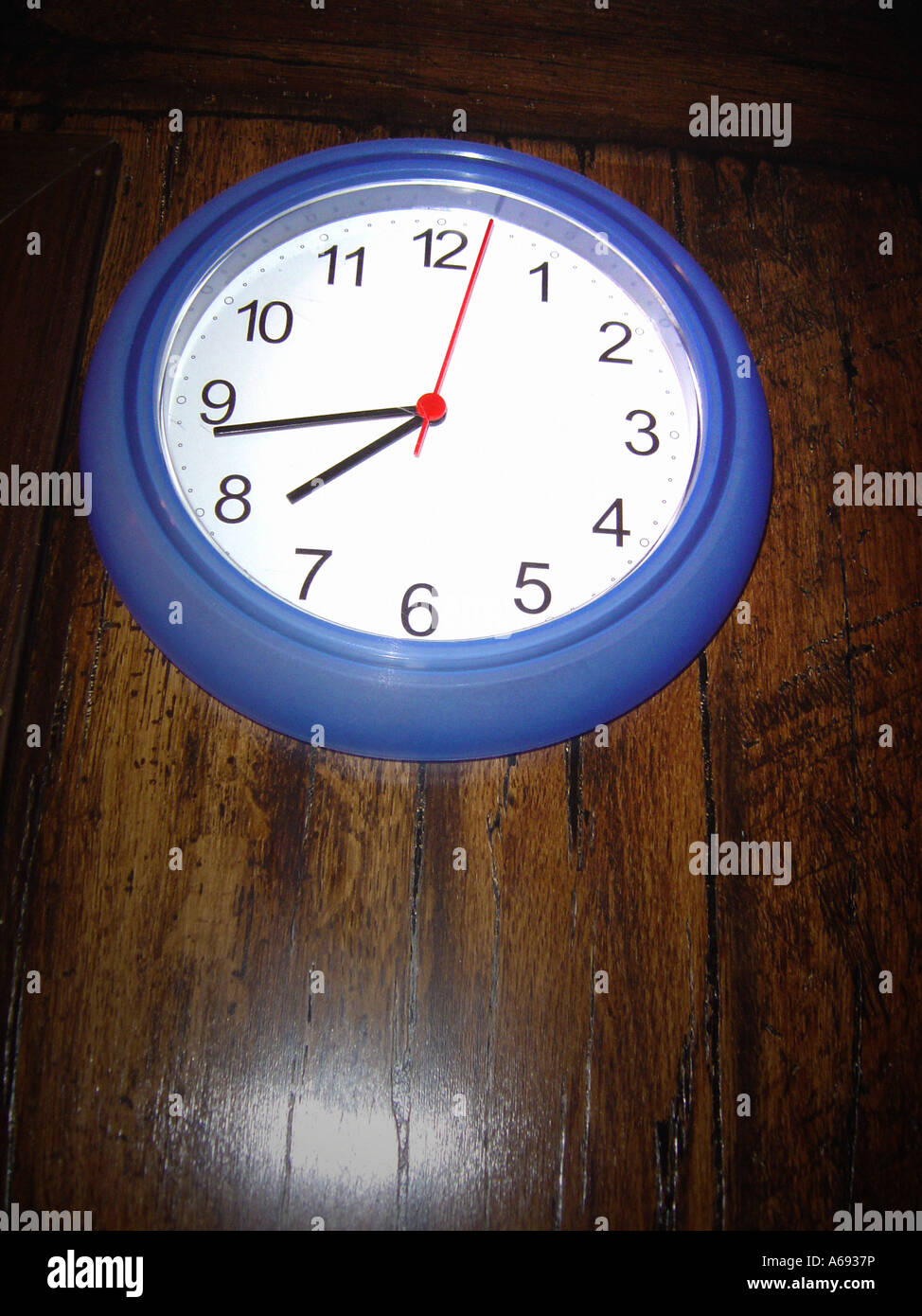 Blue Wall Clock on Wooden Paneling Wall Stock Photo - Alamy