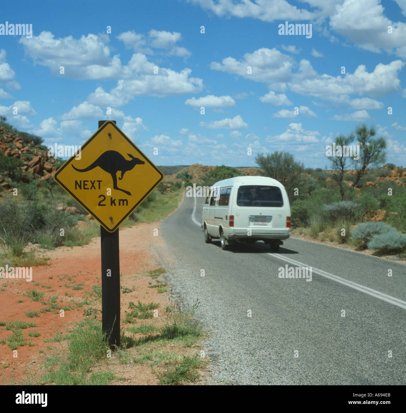 van driving on road in Australian Outback and kangaroo warning sign ...