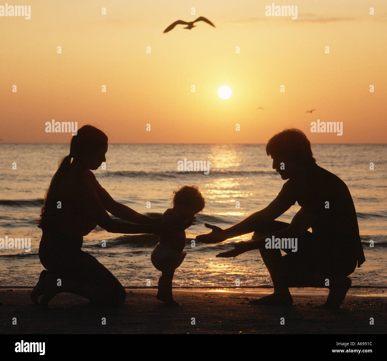 Couple baby beach sunset hi-res stock photography and images - Alamy