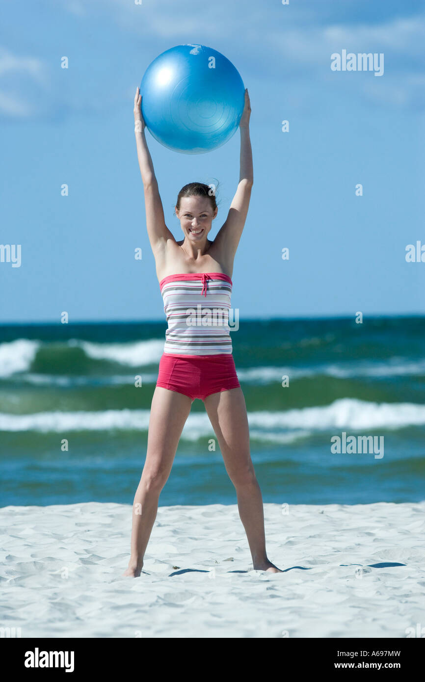 woman with fitness ball on beach Stock Photo - Alamy