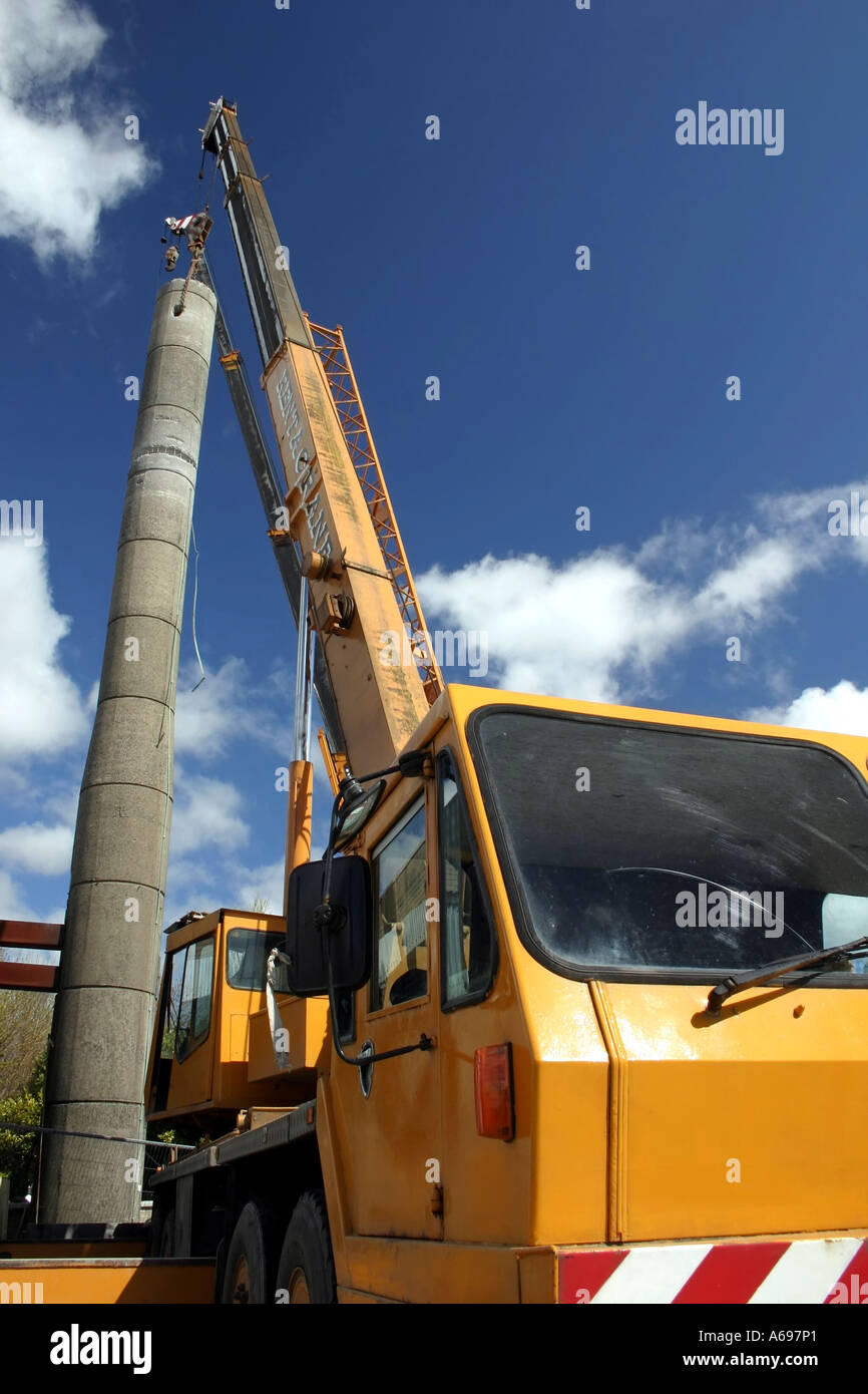 extending mobile crane in use during removal of a chimney Stock Photo ...