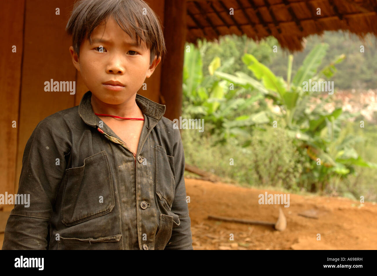 A Blue Hmong indigenous boy wearing traditional cloth proudly stands in ...