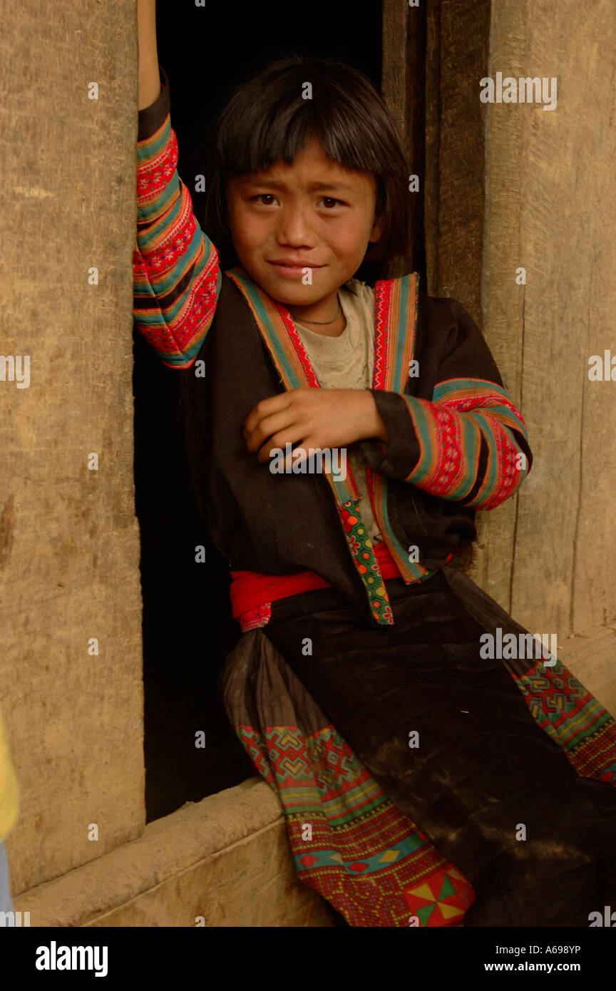 A shy Blue Hmong girl in her traditional cloth seats in the small ...