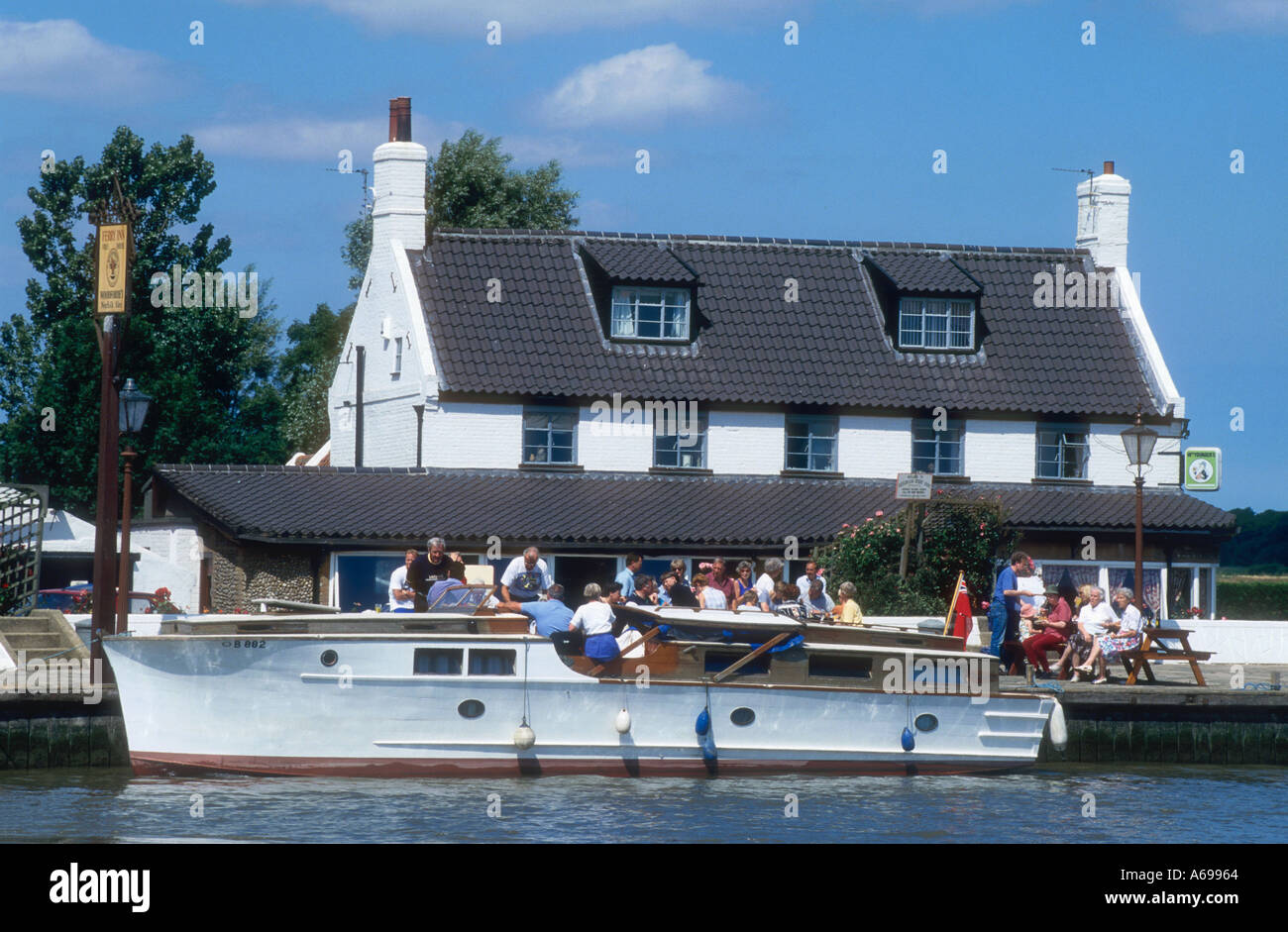 A traditional motor cruiser moored by the Ferry Inn at Reedham on the ...