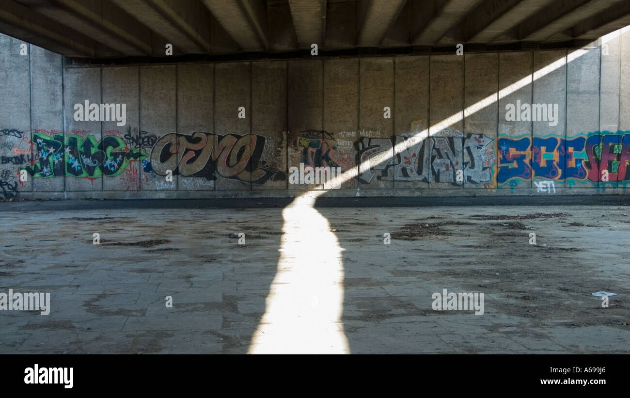 Graffiti on concrete wall under bridge Stock Photo - Alamy