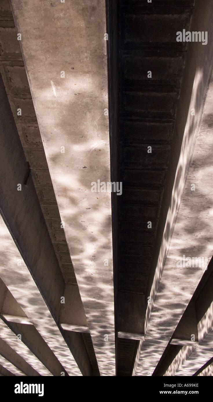 Reflection of water ripples on underside of concrete road bridge in ...