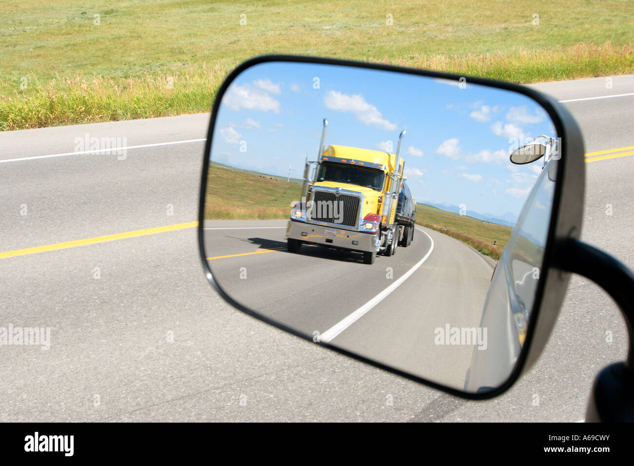 Truck reflected in side mirror on cargo van looking down highway Stock ...