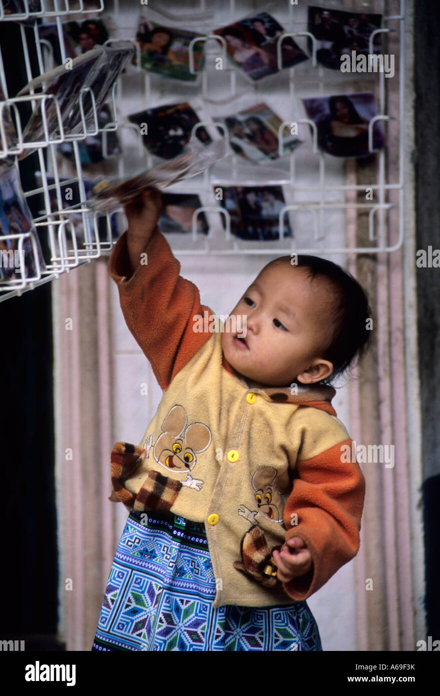Child collecting postcards from a display rack on the market of Sam ...