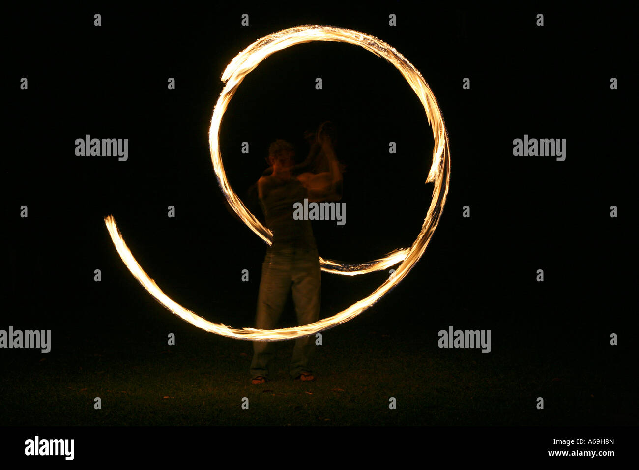 Man twirling fire sticks at a festival in Australia Stock Photo - Alamy